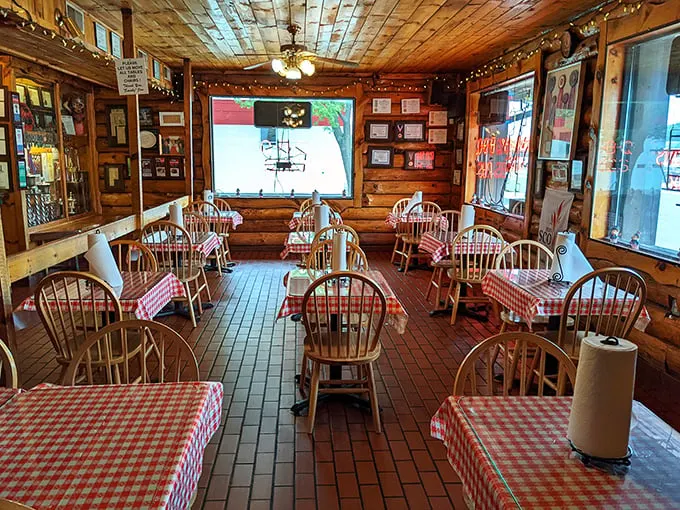 Rustic log cabin vibes and red-checkered tablecloths—this isn't just decoration, it's a time machine to when food mattered more than Instagram filters.