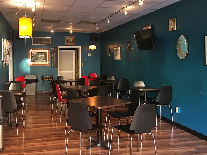 Teal walls and warm wooden floors create the perfect backdrop for both deep conversations and those "I need to be alone with my coffee" moments.