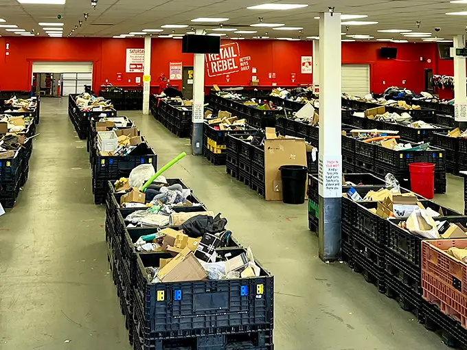 Row after row of black bins create a treasure hunter's paradise. This isn't shopping—it's an archaeological dig for modern bargain hunters.