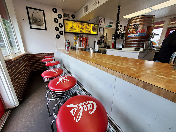Those cherry-red counter stools aren't just seating—they're front-row tickets to a burger ballet performed daily by grill masters who've perfected their craft over decades.