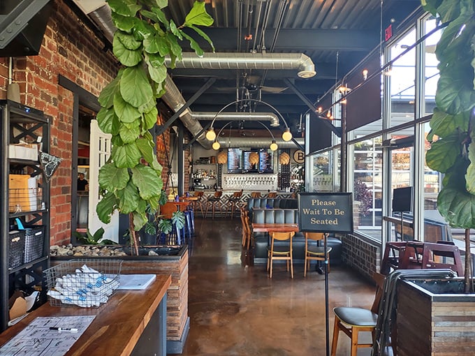 Indoor greenery cascades from the ceiling, softening the industrial-chic vibes in a space where exposed brick meets German hospitality.