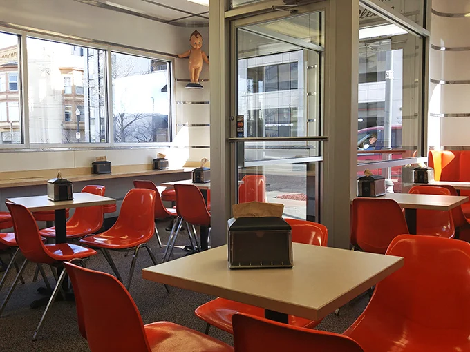 Those vibrant orange chairs aren't just seating—they're time machines to when "fast food" was still a novel concept and tasted like someone's grandma made it.