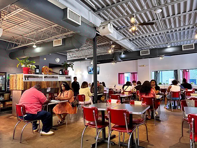 Red retro chairs invite you to settle in under industrial-chic ceilings. This isn't just a meal—it's Atlanta's morning social club in session.