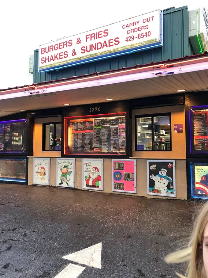 "BURGERS & FRIES, SHAKES & SUNDAES" isn't just signage—it's a declaration of purpose, complete with seasonally rotating window art that screams small-town charm.