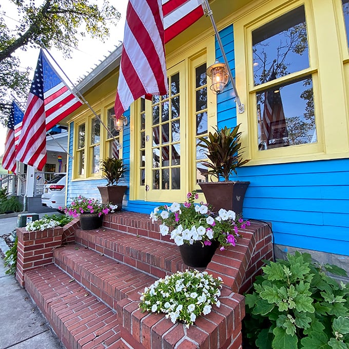 The Blue Moon's vibrant facade pops with personality—American flags and flower boxes creating a welcoming oasis in Rehoboth Beach.