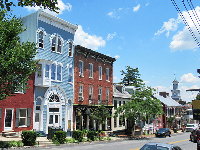 The blue Victorian beauty of Shepherdstown pops against its brick neighbors—architectural harmony that would make Frank Lloyd Wright smile.