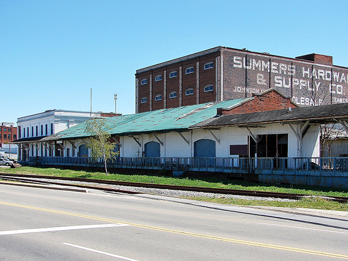Once a hardware hub, now a quiet relic—this old warehouse still whispers stories over the railroad hum.
