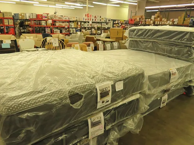 Sleep like royalty without the royal price tag – premium mattresses stacked high, each one promising better dreams than the last.