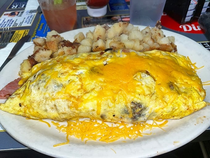 This isn't just an omelet – it's a golden sunrise on a plate, accompanied by home fries that could make a potato farmer weep with joy.
