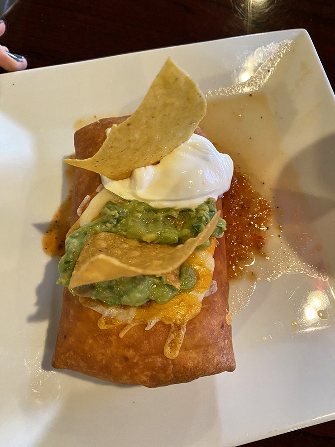 The star of the show in all its golden-fried glory—a chimichanga topped with guacamole and sour cream that makes calorie counting seem utterly pointless.
