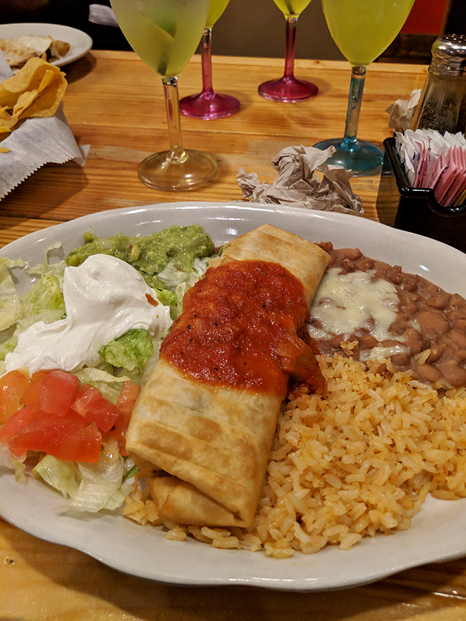 This chimichanga isn't just fried, it's transformed – a golden-brown masterpiece accompanied by the holy trinity of rice, beans, and fresh toppings. 