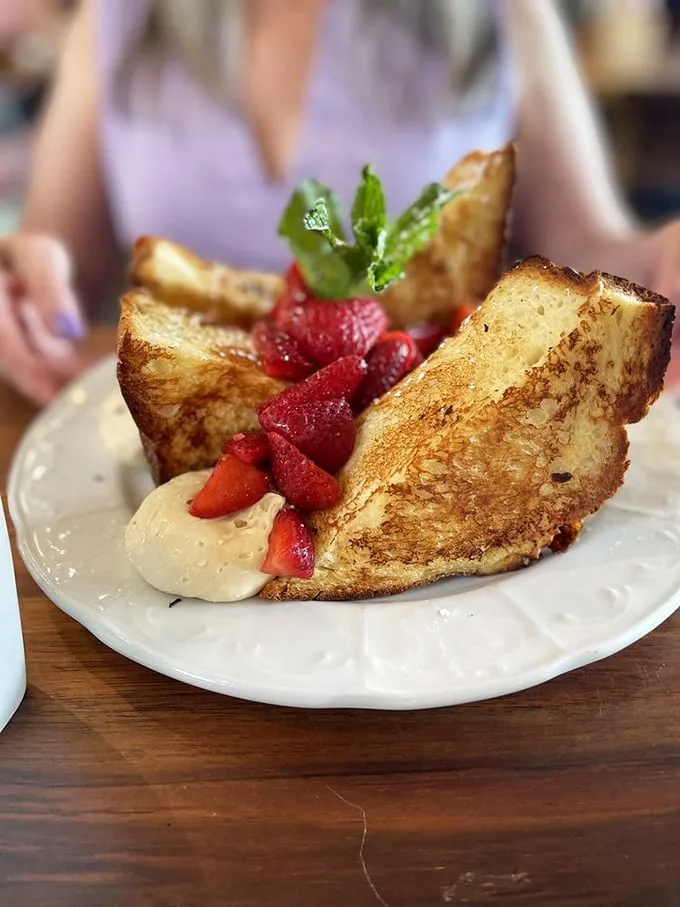 French toast that's clearly been to finishing school – golden-crisp exteriors with custardy centers that make morning worth facing.