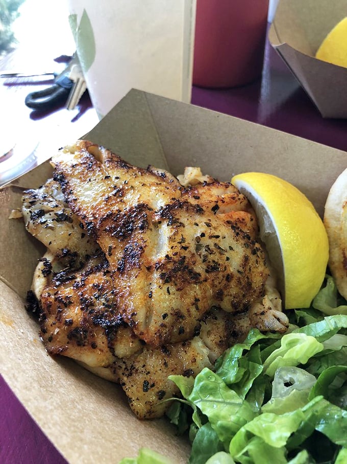 Beach dining perfection: a blackened grouper sandwich that makes you wonder why you ever eat anything else. That sauce? Liquid gold.