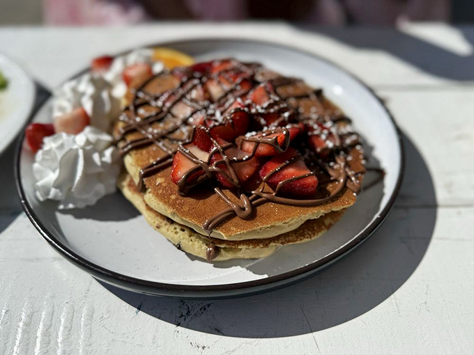 Pancakes adorned with strawberries, chocolate drizzle, and whipped cream—proof that sometimes the most important meal of the day doubles as dessert.