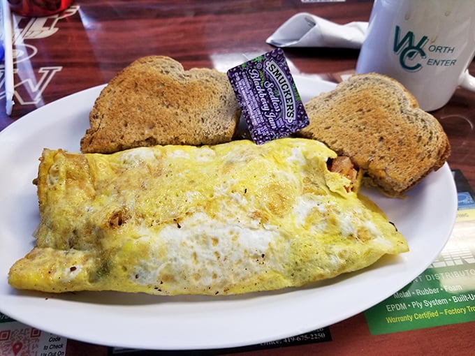 This omelet doesn't just hang off the plate—it establishes dominance over it, with a side of toast standing by like loyal subjects.