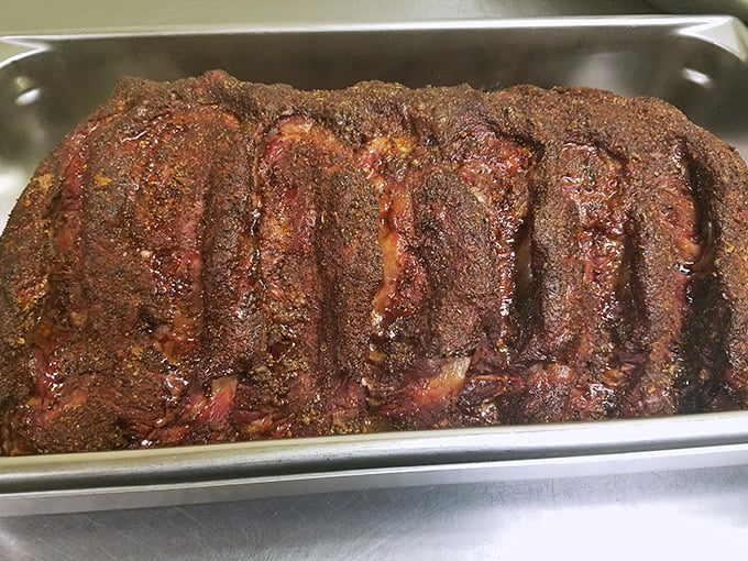 These ribs aren't just cooked—they're transformed through smoke and time into something primal and perfect, wearing their spice rub like a badge of honor.