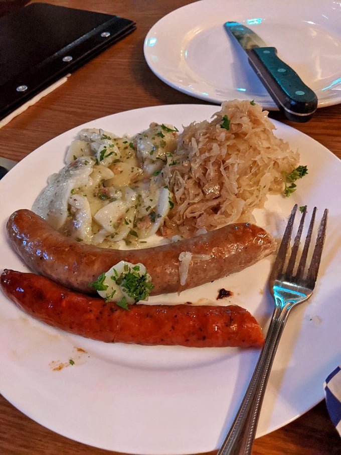 Two perfect sausages—crisp-skinned and succulent—nestled beside that legendary potato salad. This plate is Munich's greatest hit album.