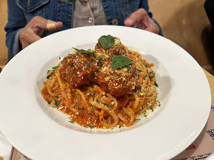 These meatballs don't just sit on the pasta—they reign supreme, like tiny kings atop their saucy, twirly throne.