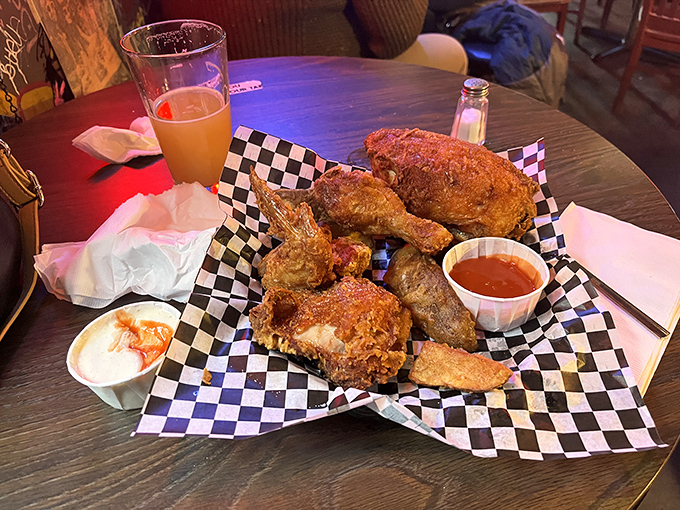 Golden-brown perfection served on checkered paper. This isn't just fried chicken—it's edible artwork with a crispy exterior that shatters like glass.