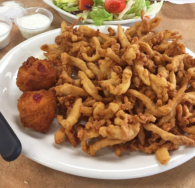 Golden-fried clams piled high on a plate—crispy, tender, and worth every mile of your journey to this Oklahoma seafood haven.