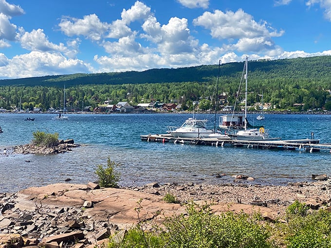 Boats bobbing in the protected harbor tell stories of adventure while the forested hills stand guard like patient sentinels.