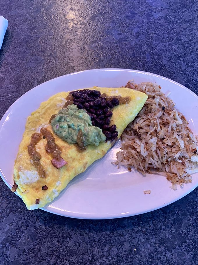 Breakfast nirvana achieved: a perfectly executed omelet alongside those legendary hash browns. This plate doesn't just feed you—it hugs your soul.