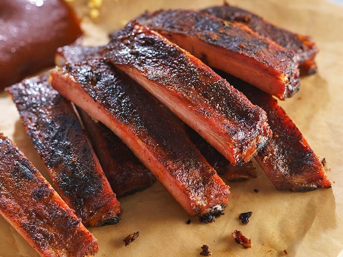 These ribs don't just fall off the bone—they practically leap into your mouth, their smoke ring a badge of honor earned through hours of patient cooking.