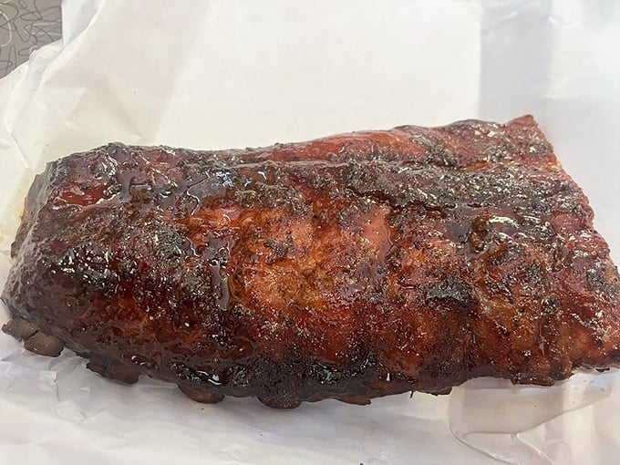 These ribs don't just fall off the bone - they practically leap into your mouth, their apricot-glazed crust glistening like edible stained glass.