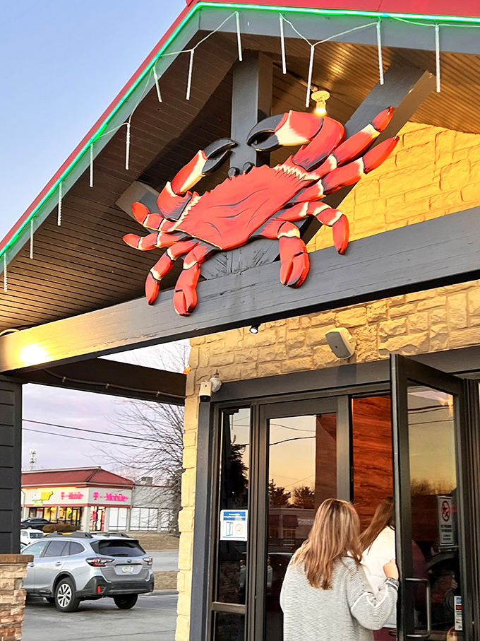The giant crab perched above Juicy Seafood warns diners: messy hands and happy faces ahead.
