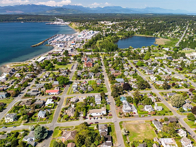 From above, Port Townsend reveals its perfect positioning—a peninsula embraced by water on three sides with the Olympic Mountains standing guard in the distance.