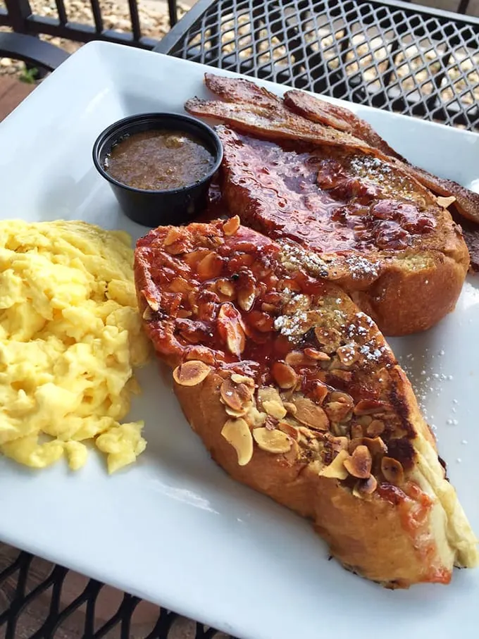 The Almond Three Legion French toast arrives with perfectly scrambled eggs—a breakfast duo that deserves its own morning talk show. 