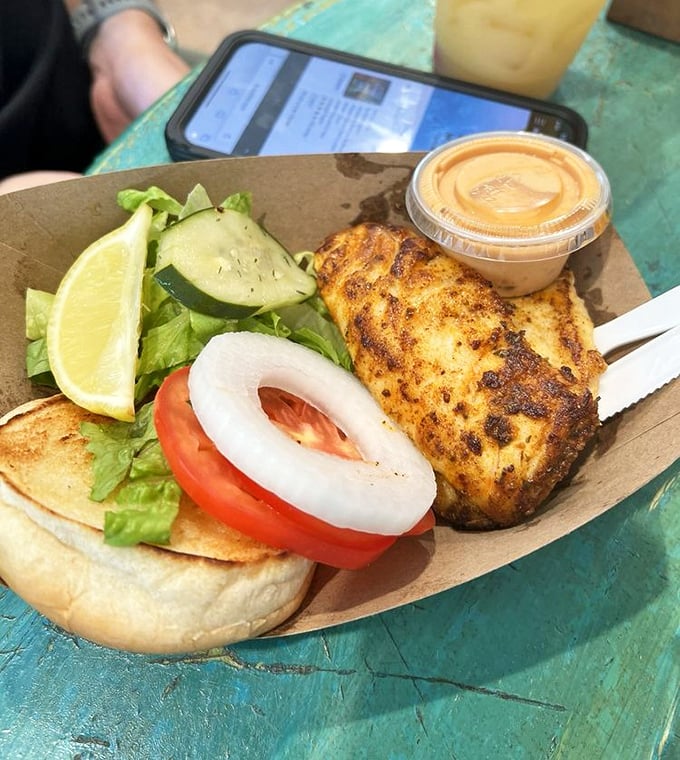 The blackened mahi sandwich arrives like seafood royalty on its paper throne. One bite and you'll understand why locals keep this place secret.