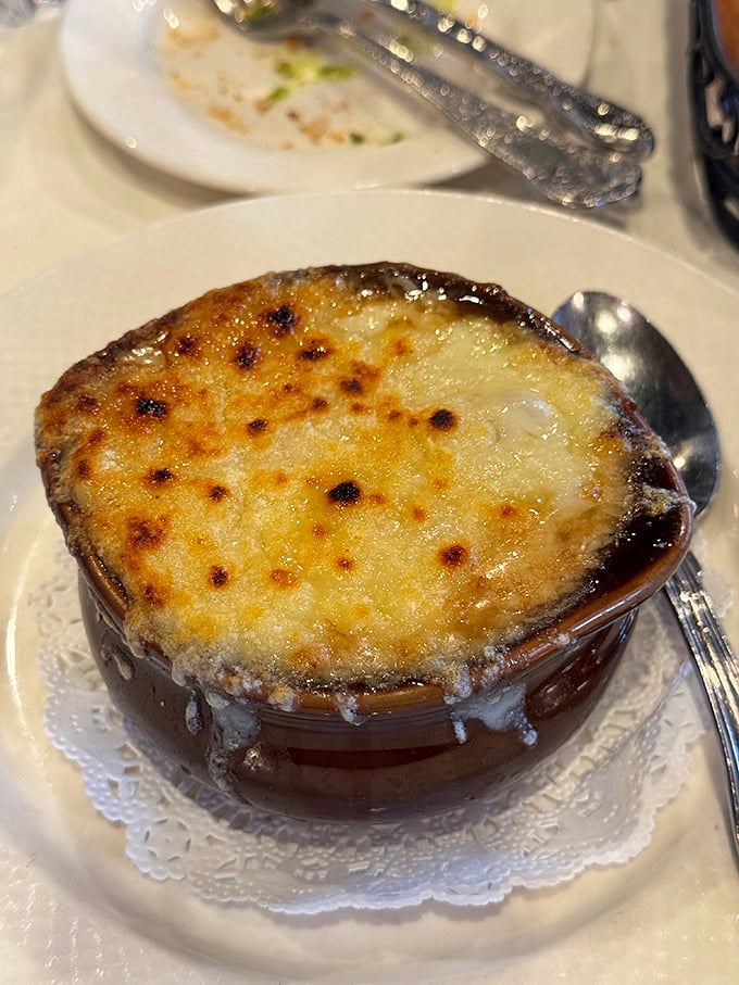 This isn't just soup—it's a commitment to excellence. The caramelized onions beneath that magnificent cheese cap have been simmering their way to perfection for hours.