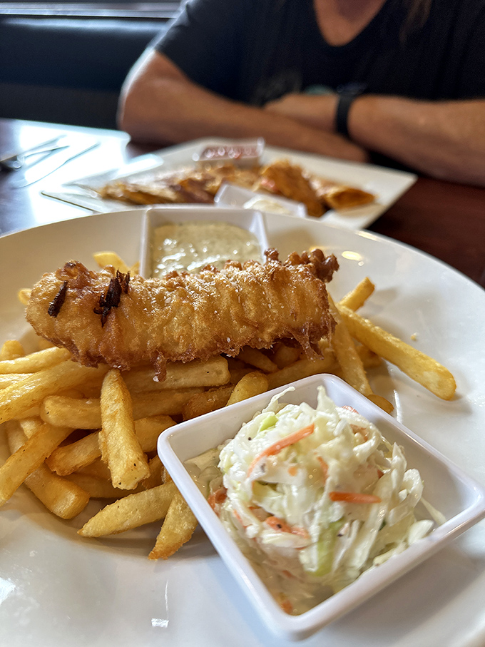 The holy trinity of comfort food: perfectly battered fish, golden fries, and creamy coleslaw that actually deserves space on your plate.