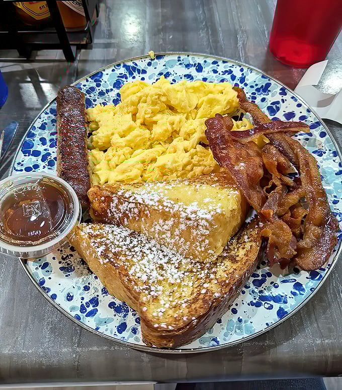 The perfect breakfast symphony: golden French toast conducting an orchestra of crispy bacon, fluffy eggs, and savory sausage.