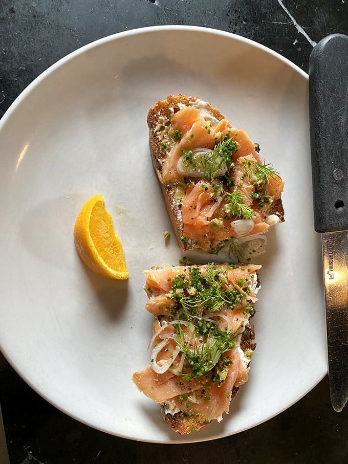 The LOX toast arrives like edible art—salmon draped elegantly over cream cheese with fresh dill playing the role of confetti at this breakfast celebration.