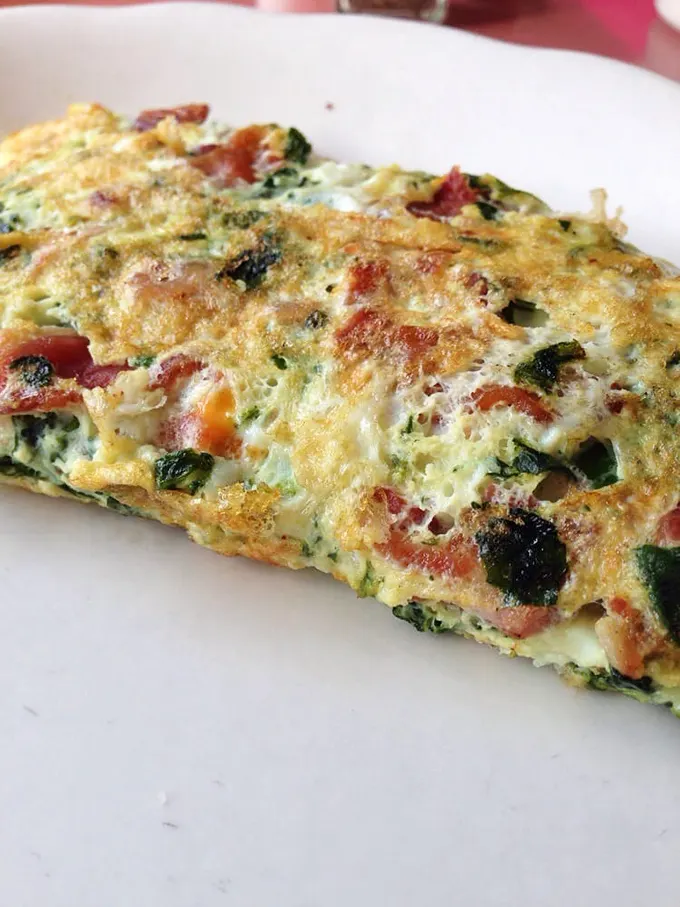This isn't just any omelet—it's what happens when vegetables and cheese decide to throw a morning party on your plate.