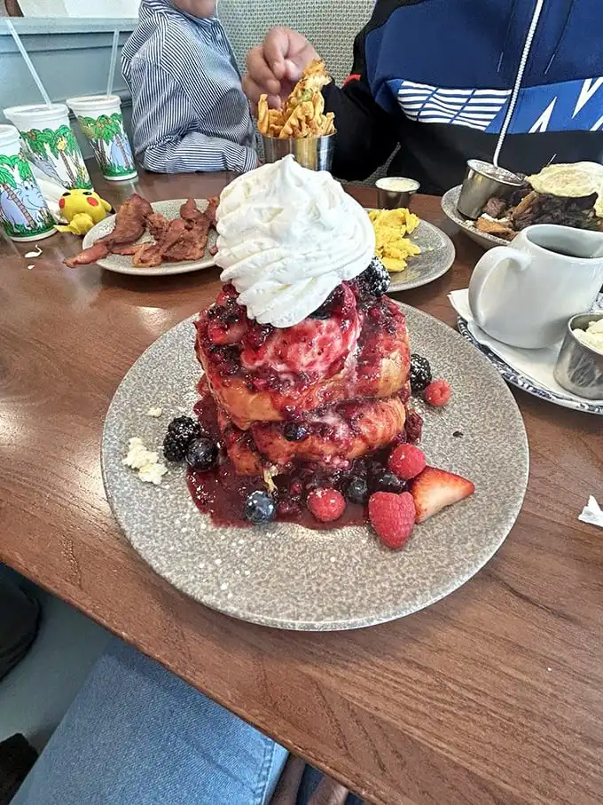 The Berry Yogurt French Toast in all its glory – a tower of brioche crowned with fresh berries and whipped cream that's breakfast and dessert in one glorious package.