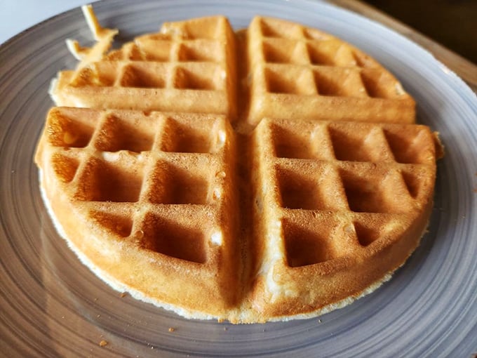Golden waffle architecture at its finest. Those perfect squares are actually tiny pools waiting for butter and syrup to create breakfast magic.