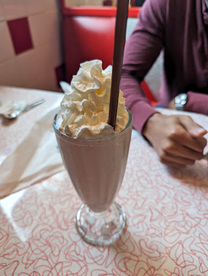 This chocolate milkshake isn't just thick—it's plotting world domination from its glass fortress. The straw stands at attention, practically daring you to attempt the first sip.
