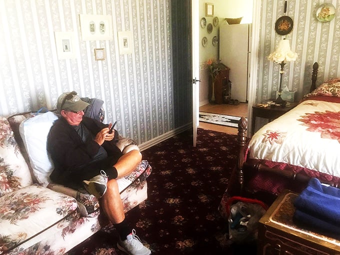 When knights need to check their messages—a guest relaxes in period-appropriate surroundings with decidedly modern technology. Medieval comfort meets Wi-Fi in this cozy chamber.