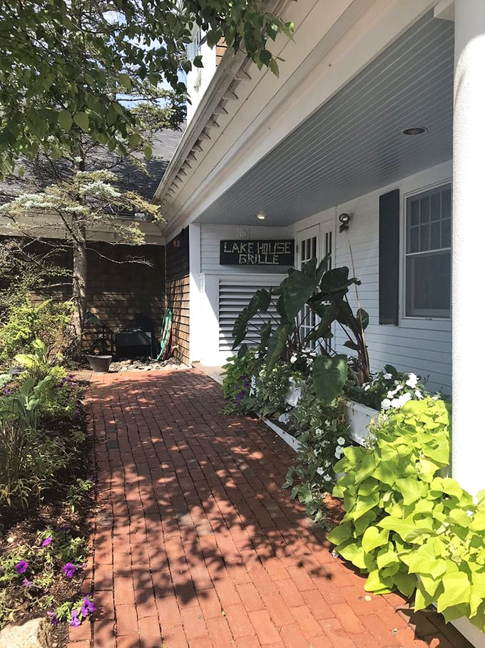 The lush garden path leading to Lakehouse Grille—where every flower seems to whisper, "The prime rib is exceptional today."