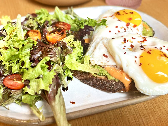 Two sunny eggs perched atop avocado toast like breakfast royalty—a dish so photogenic it probably has its own Instagram following.