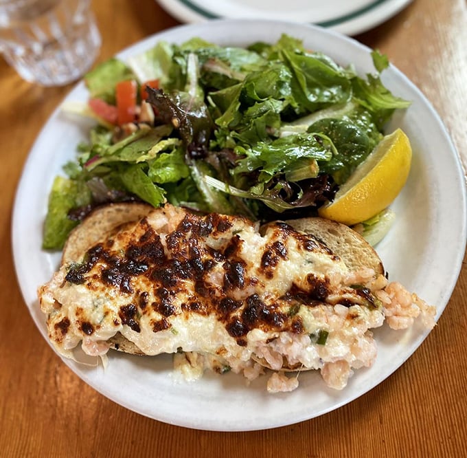 This isn't just a sandwich; it's a coastal romance—broiled shrimp nestled under melted cheese with a crisp salad playing wingman.