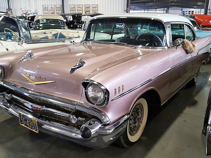The pink 1957 Chevy Bel Air represents peak Americana—when cars had fins that could double as spacecraft and colors borrowed from ice cream parlors.