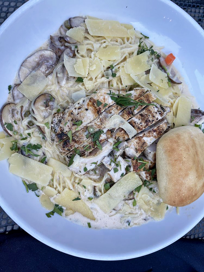 Pasta that doesn't just sit on the plate—it performs! Grilled chicken atop creamy fettuccine with mushrooms and fresh herbs.
