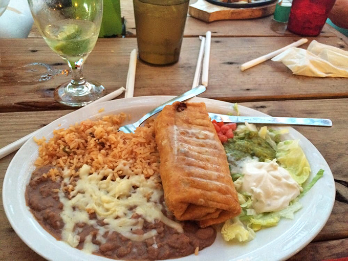 
A chimichanga that's dressed to impress, flanked by Spanish rice and refried beans topped with melted cheese – the backup singers who deserve their own spotlight. 