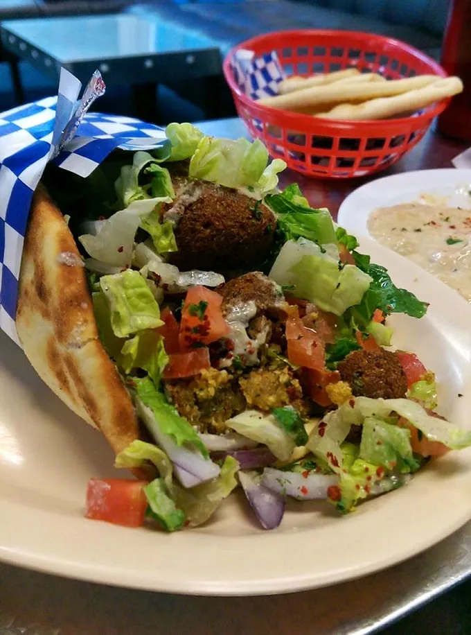 Falafel that doesn't just sit on the plate—it performs! Crispy, herb-flecked spheres nestled in fresh greens with a supporting cast of vibrant vegetables.