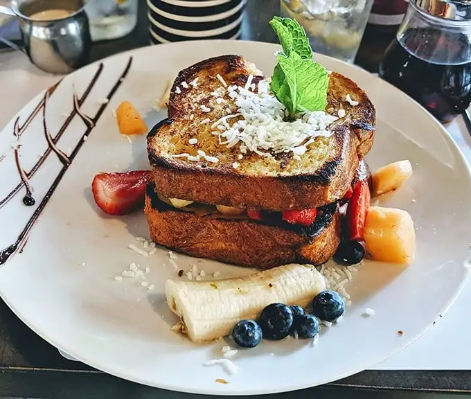 Breakfast sandwich or dessert masterpiece? This French toast creation blurs the lines deliciously, with a drizzle of chocolate that means business.