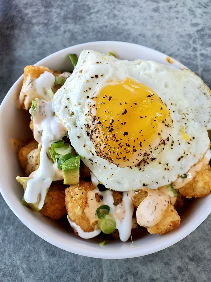 Tater tots graduated from school lunch to culinary masterpiece. That perfectly fried egg on top is like the valedictorian's speech—the crowning achievement.